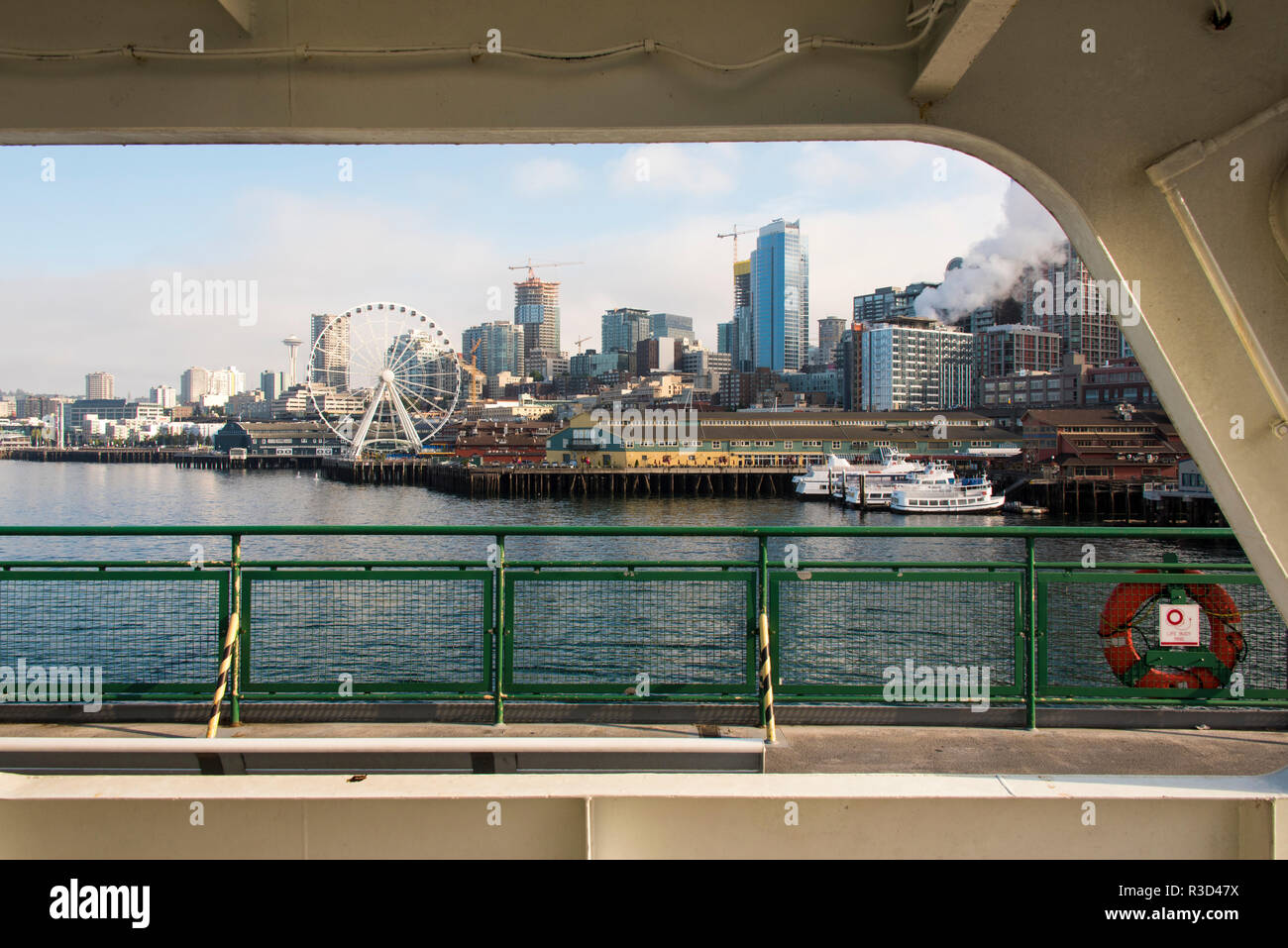 USA, WA, Seattle. Waterfront in morning sun framed by ferry structure ...