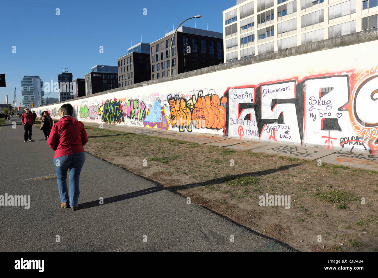 Berlin Germany - The Berlin Wall visitors walking along a section at ...