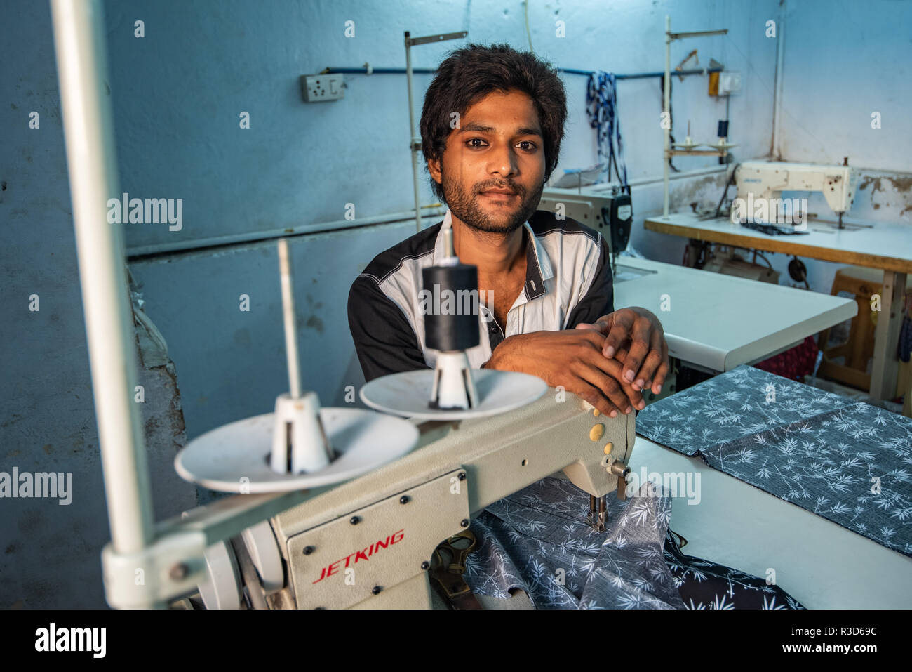 A tailor takes a moments break from his work for a photo in a small ...