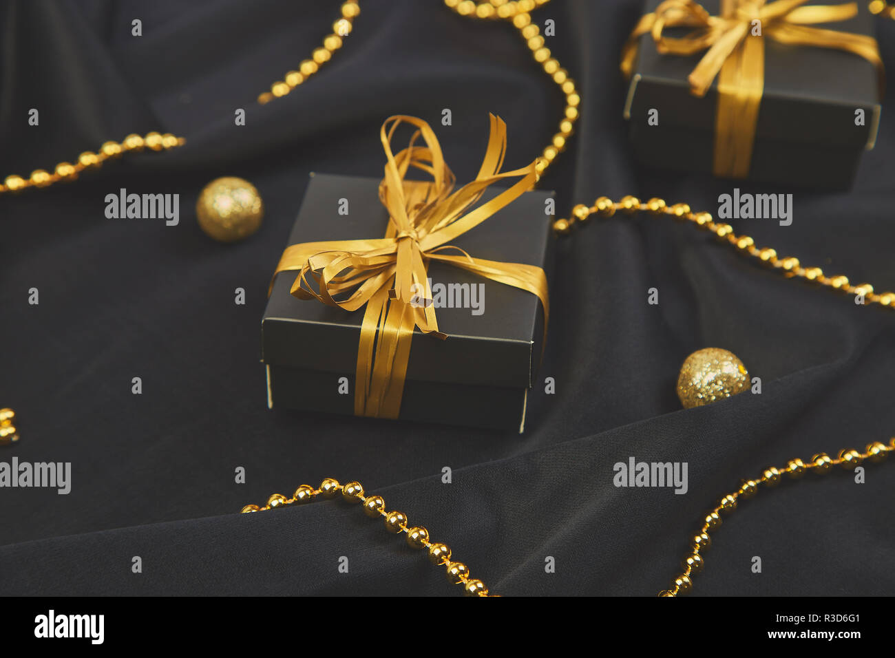 Luxury black gift boxes with gold ribbon on shine background. Christmas ...
