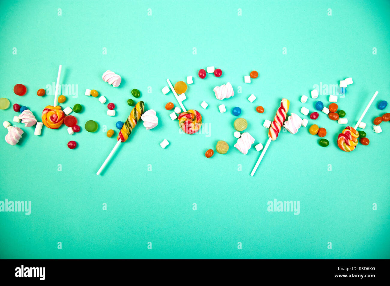 Colorful candies on pastel turquoise background. Flat lay, top view ...