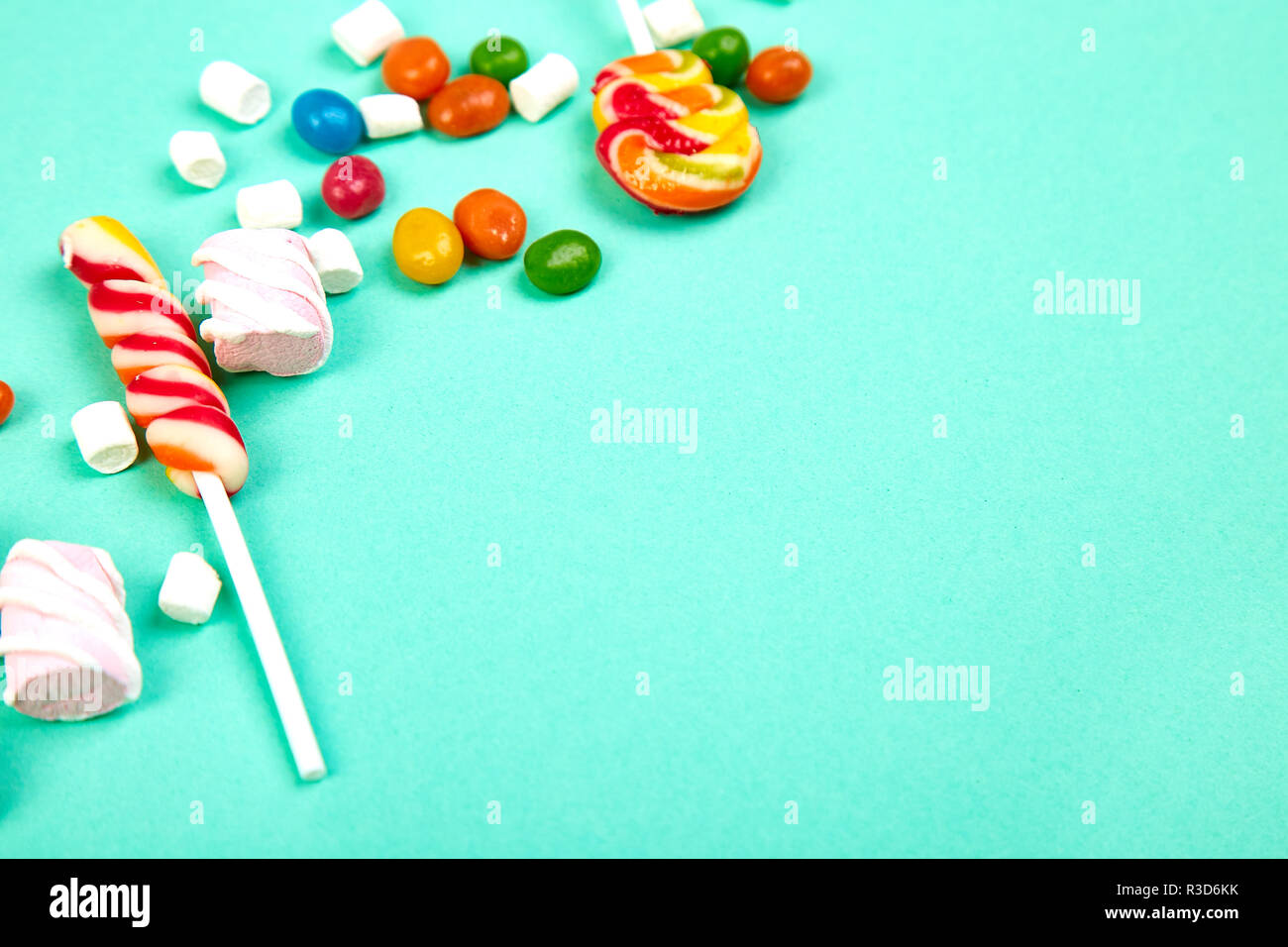 Colorful candies on pastel turquoise background. Flat lay, top view ...
