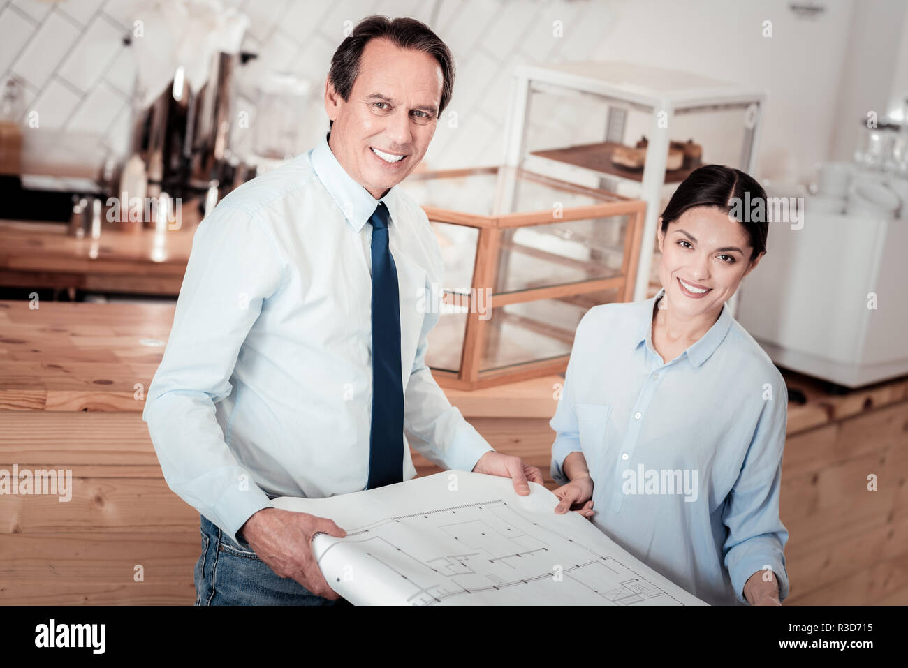Professional plan. Nice smart people holding a drawing while working a ...