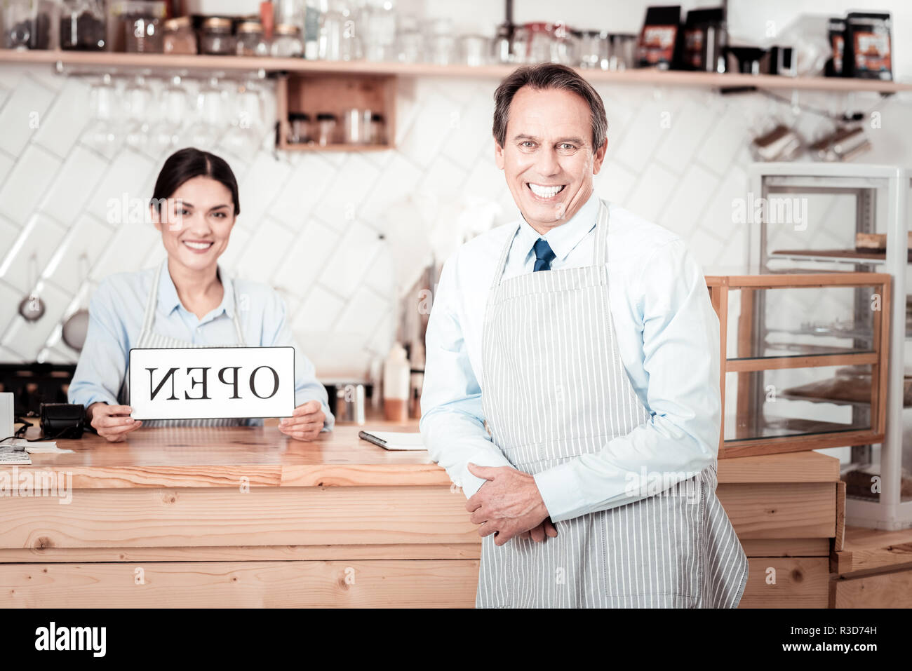 Welcome to us. Positive joyful man smiling while greeting you in his ...