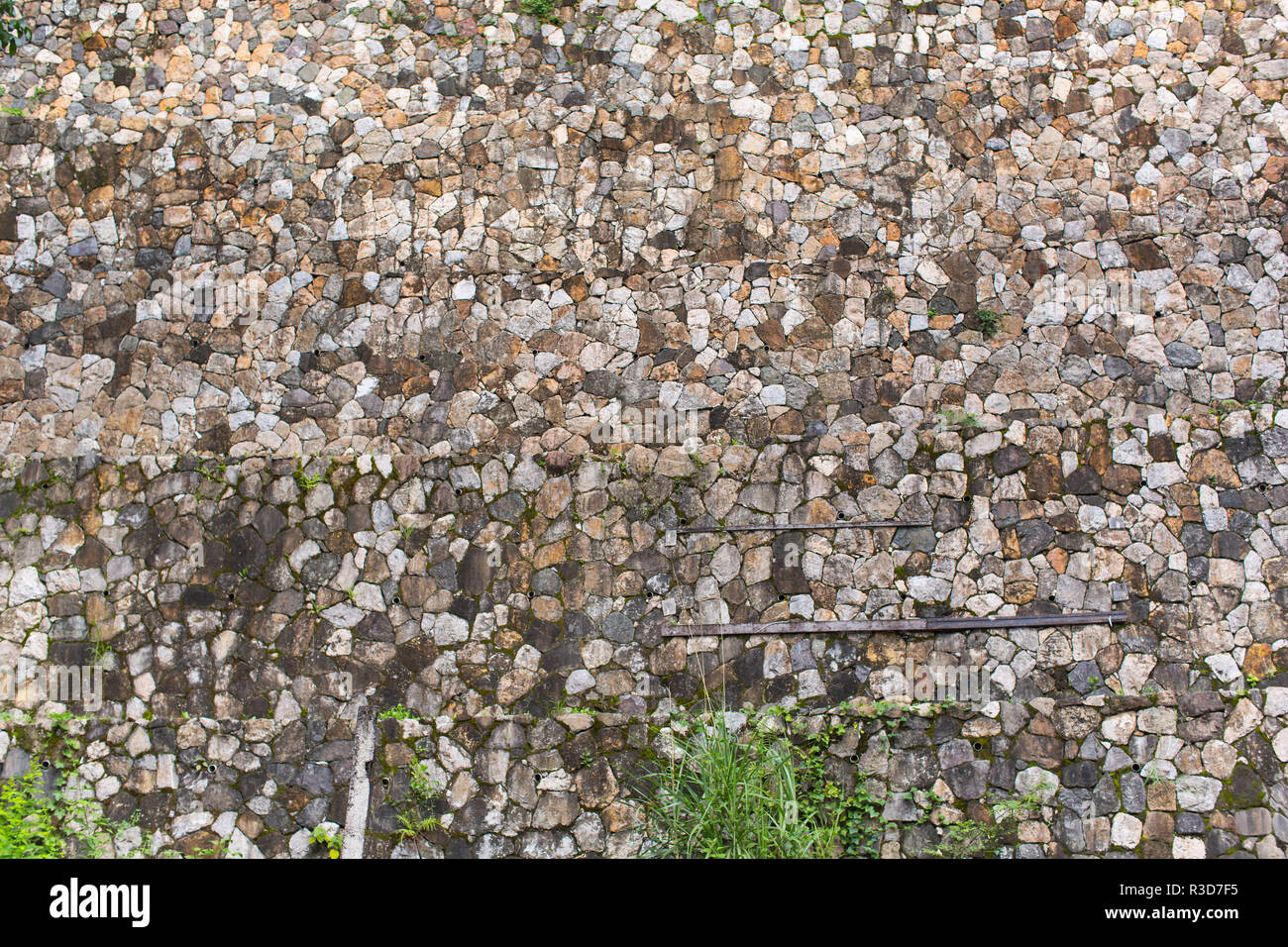 big broken stone wall, rubble work wall, with grass colorful and ...