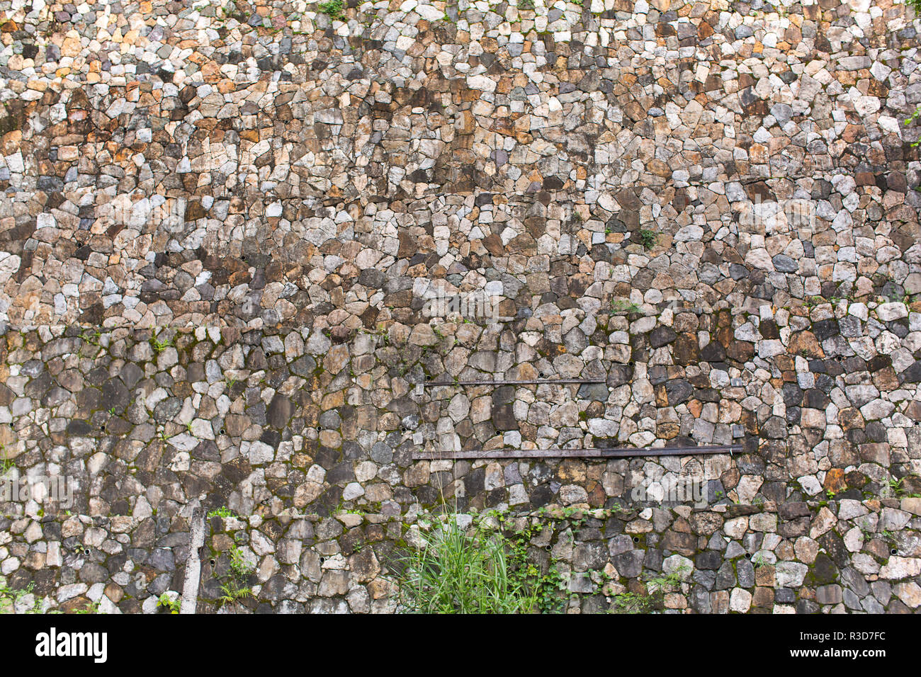 big broken stone wall, rubble work wall, with grass colorful and ...