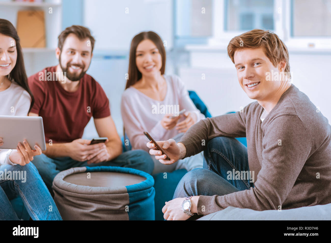 Digital era. Optimistic four friends using gadgets and grinning Stock ...