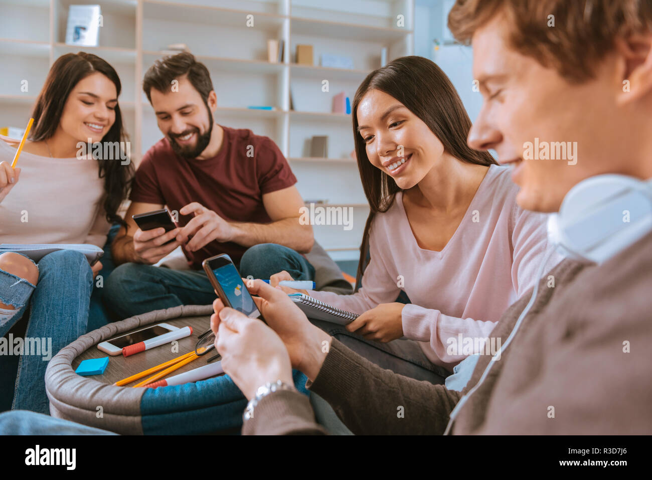 Technology everywhere. Exuberant four friends using gadgets and ...