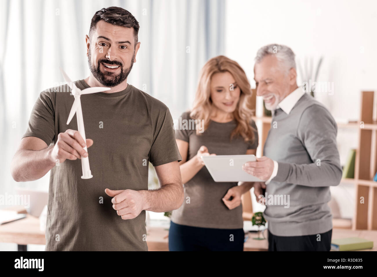 Good work. Alert handsome man smiling and holding a turbine tower ...