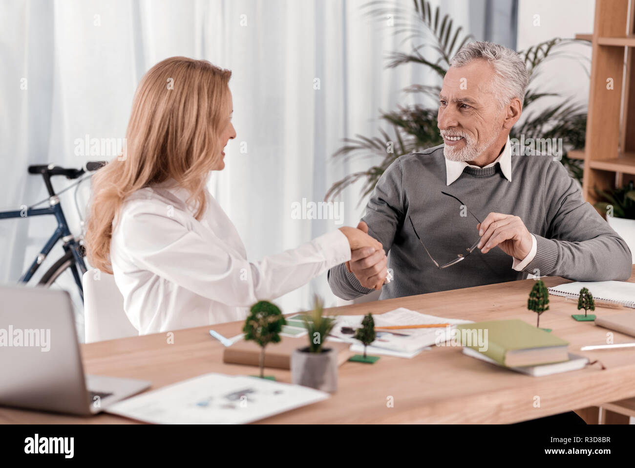 Great job. Cheerful blond woman smiling and shaking hands with her ...