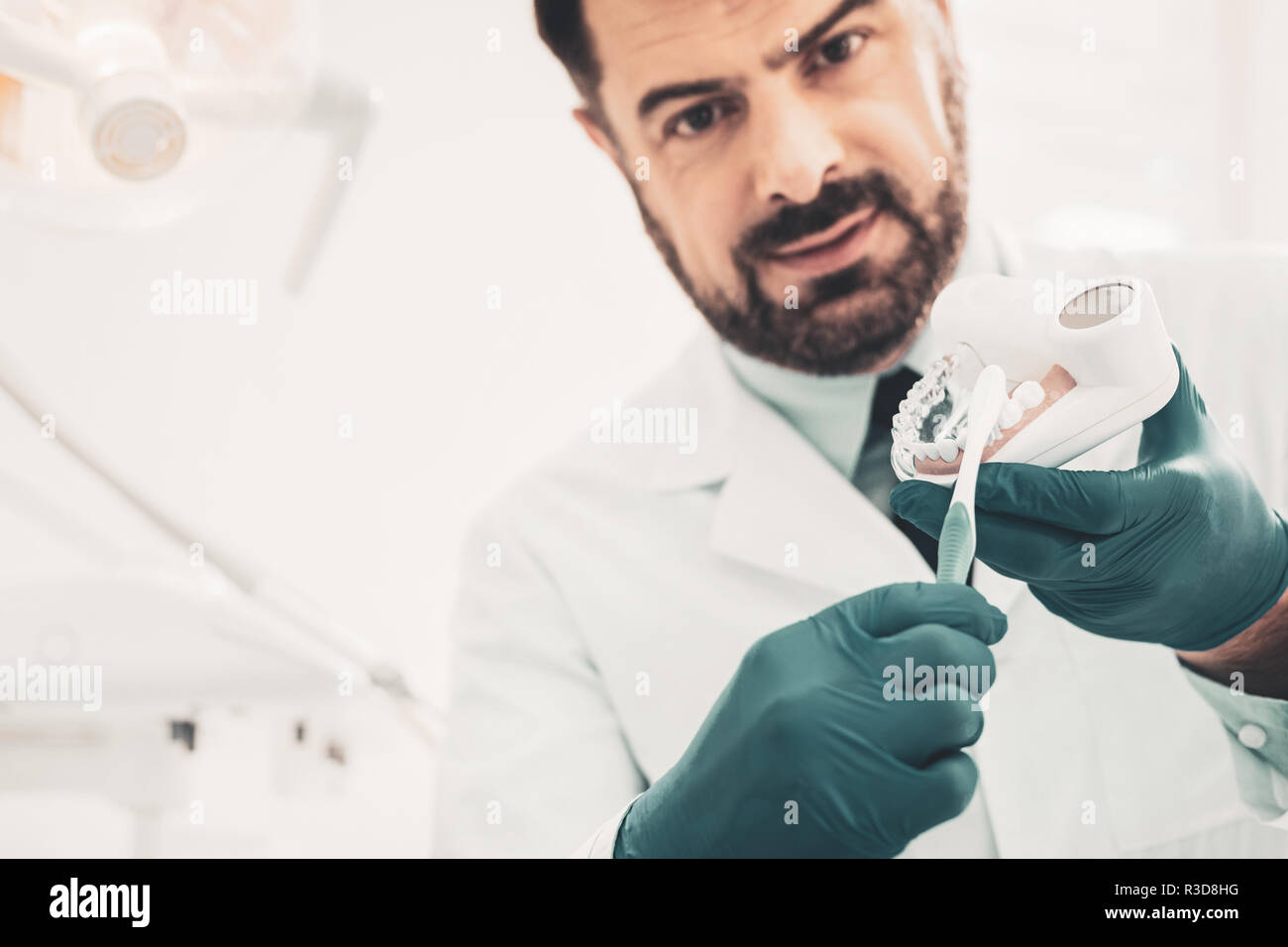 Proper teeth cleaning. Close up of serious doctor with toothbrush and ...
