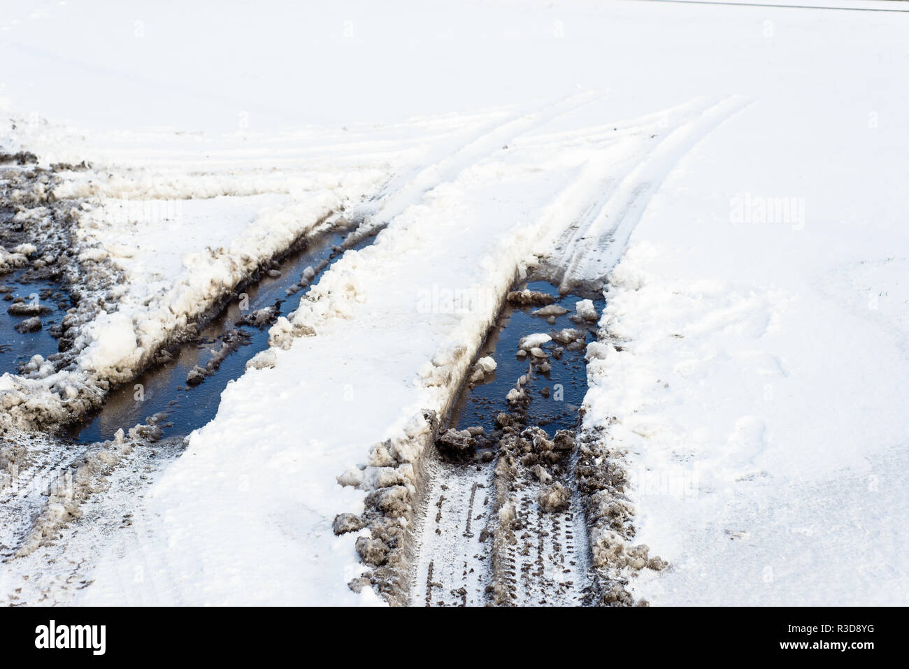 Winter on road, snow texture with tire tracks and puddle of mud in ...