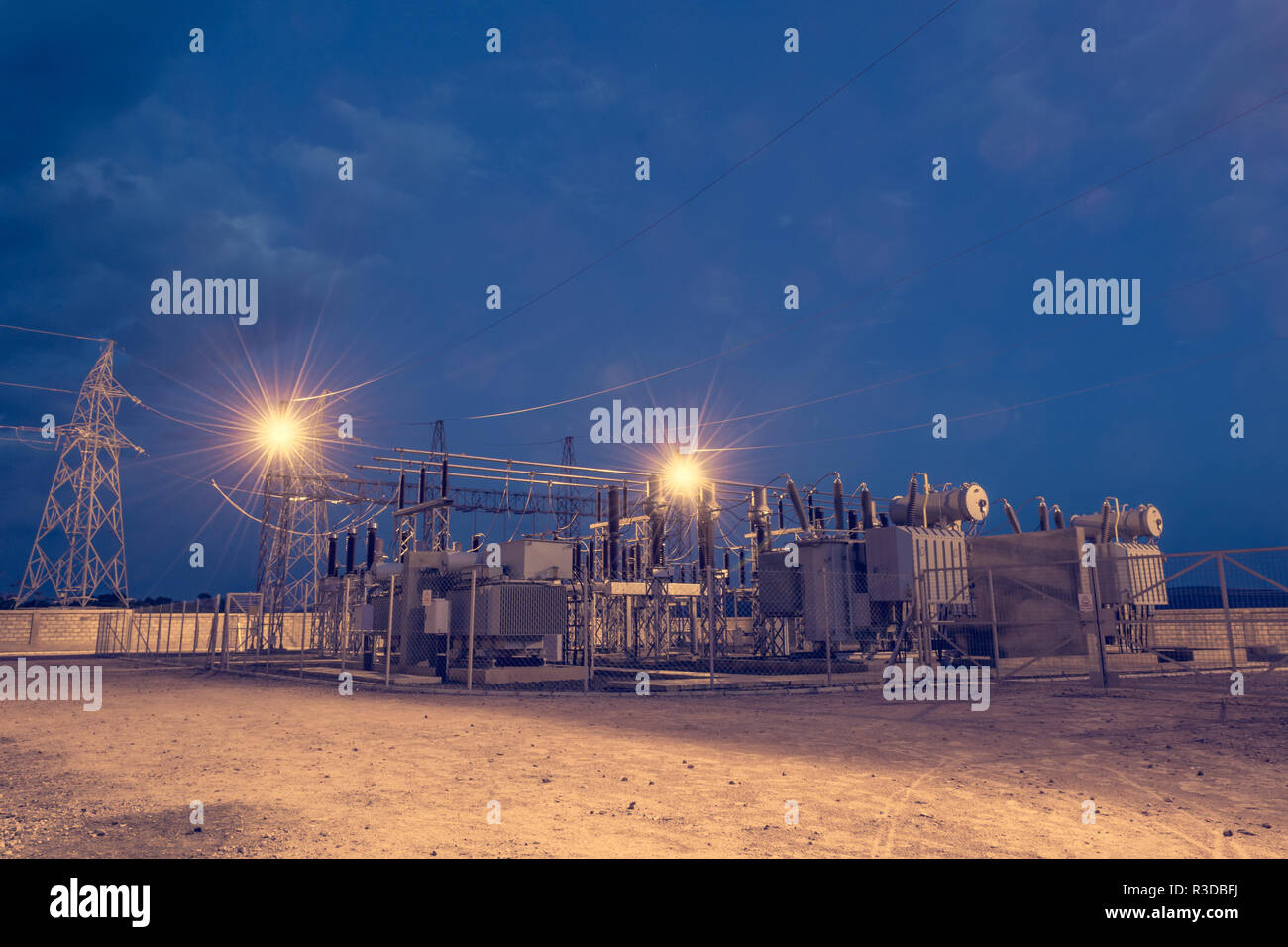 Electrical power substation illuminated by lights at night. Deliver ...