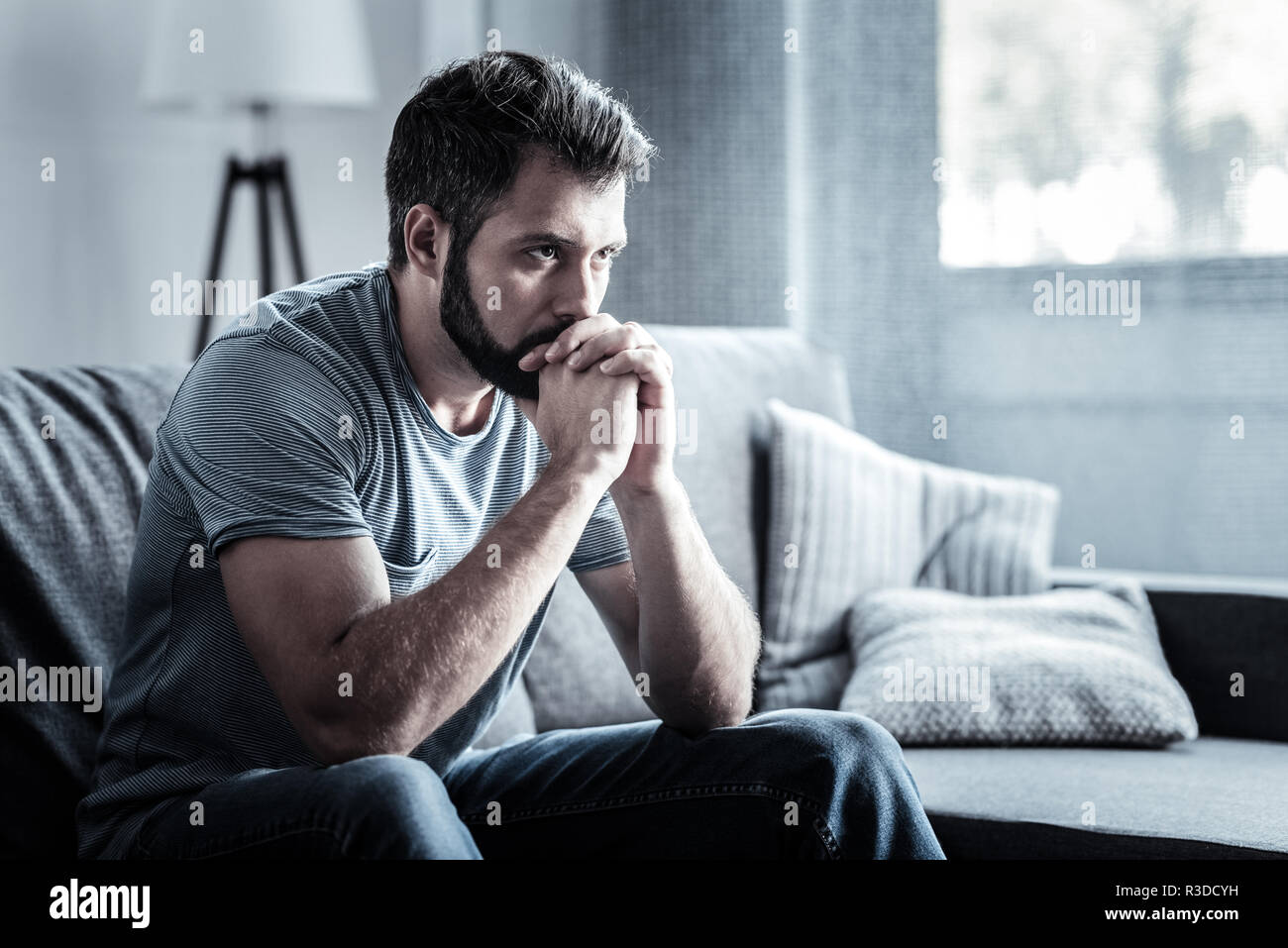 Have a problem. Serious male person holding hands together and leaning ...