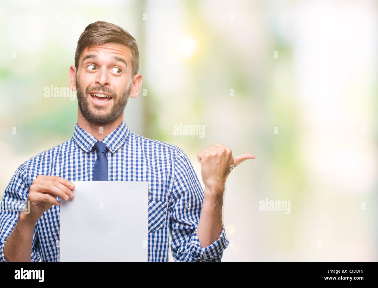 Young handsome man holding blank paper over isolated background ...