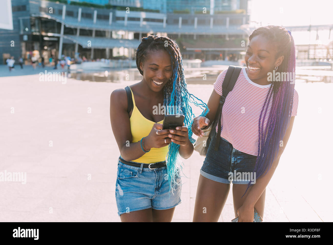 two women sisters outdoor using smart phone having fun - happiness ...