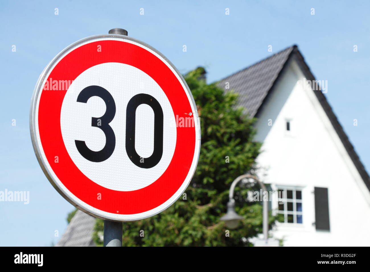 Road sign Tempo 30 Zone, one-family house in the background, Germany ...