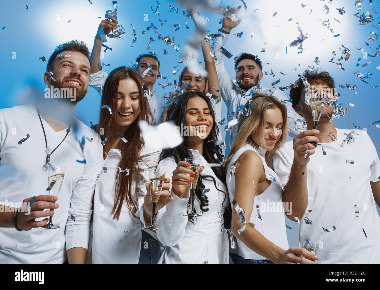Group of cheerful joyful young people standing and celebrating together ...