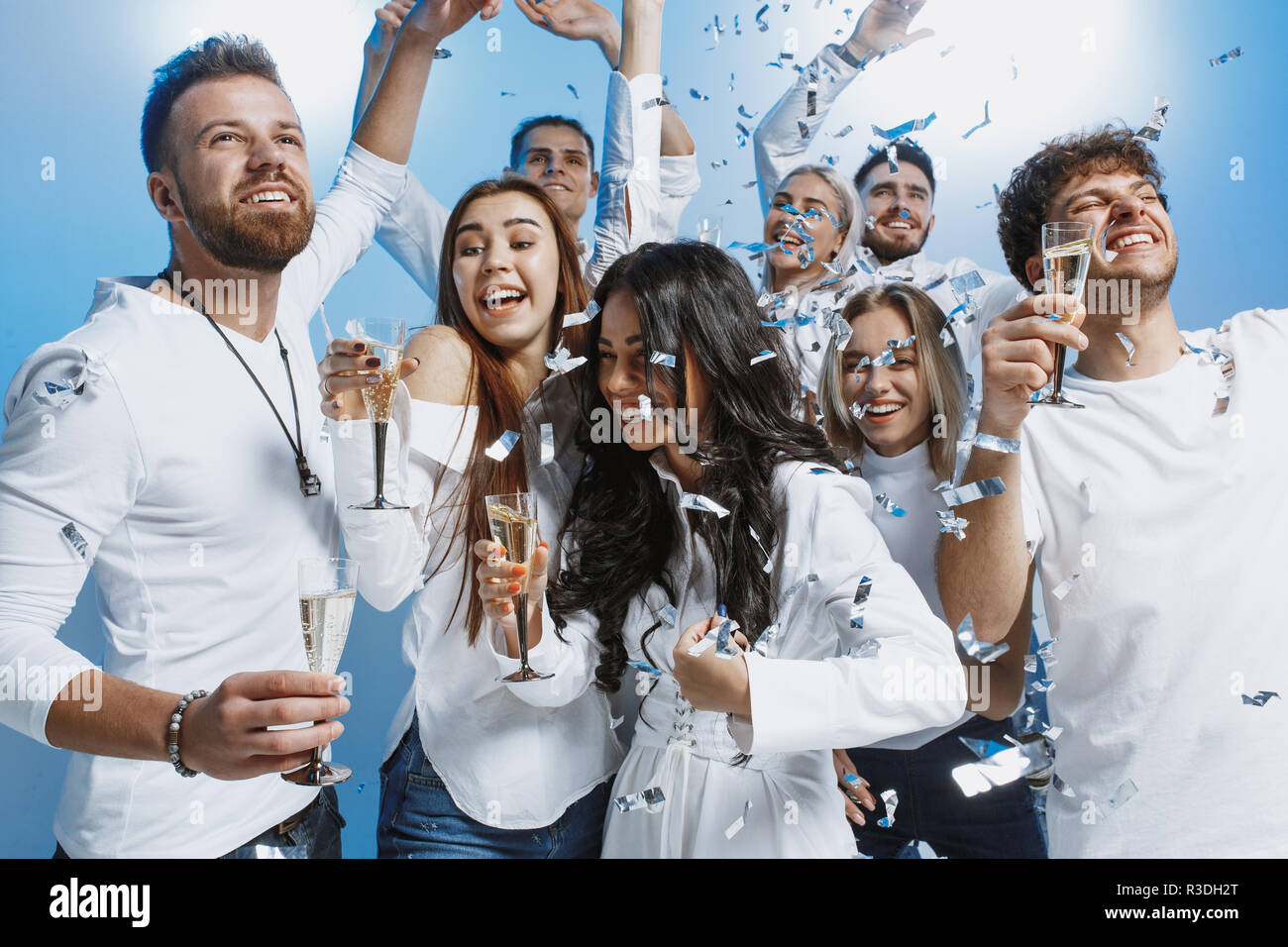 Group of cheerful joyful young people standing and celebrating together ...