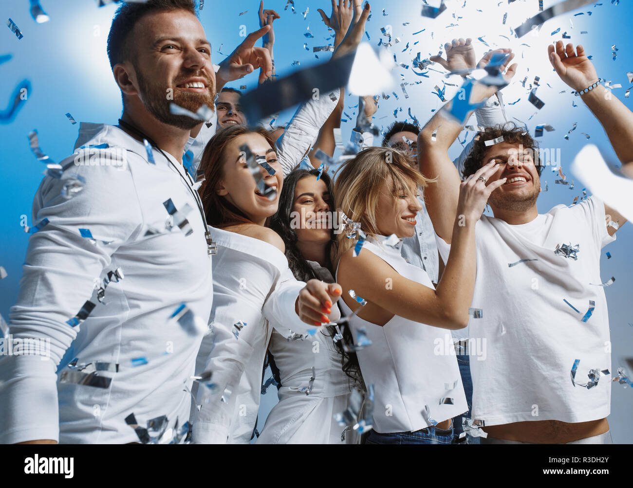 Group of cheerful joyful young people standing and celebrating together ...