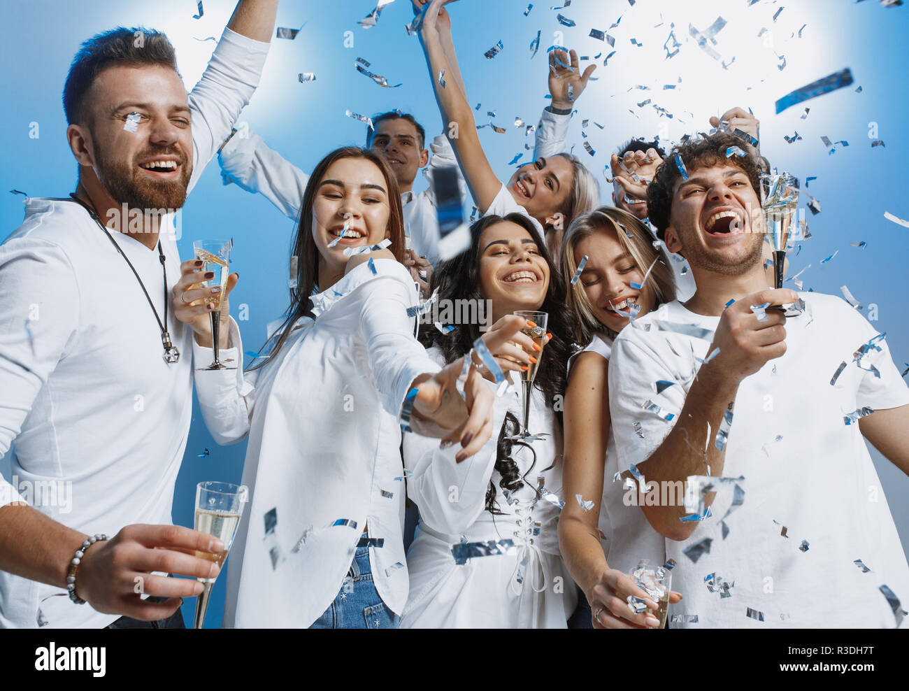 Group of cheerful joyful young people standing and celebrating together ...