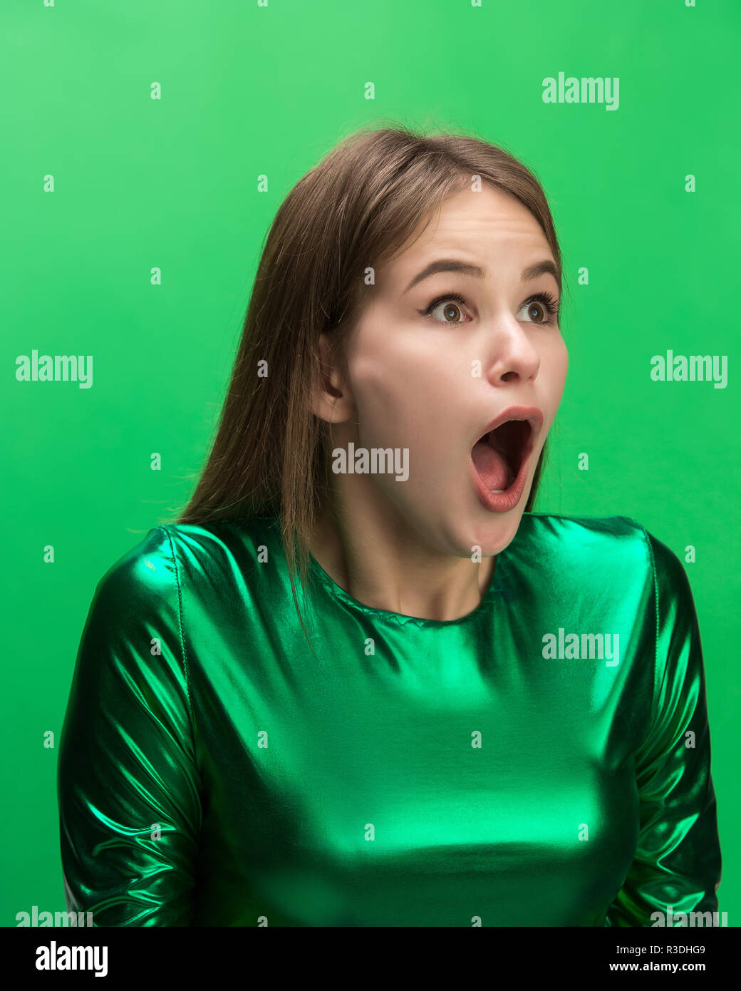 The surprised and astonished young woman screaming with open mouth ...