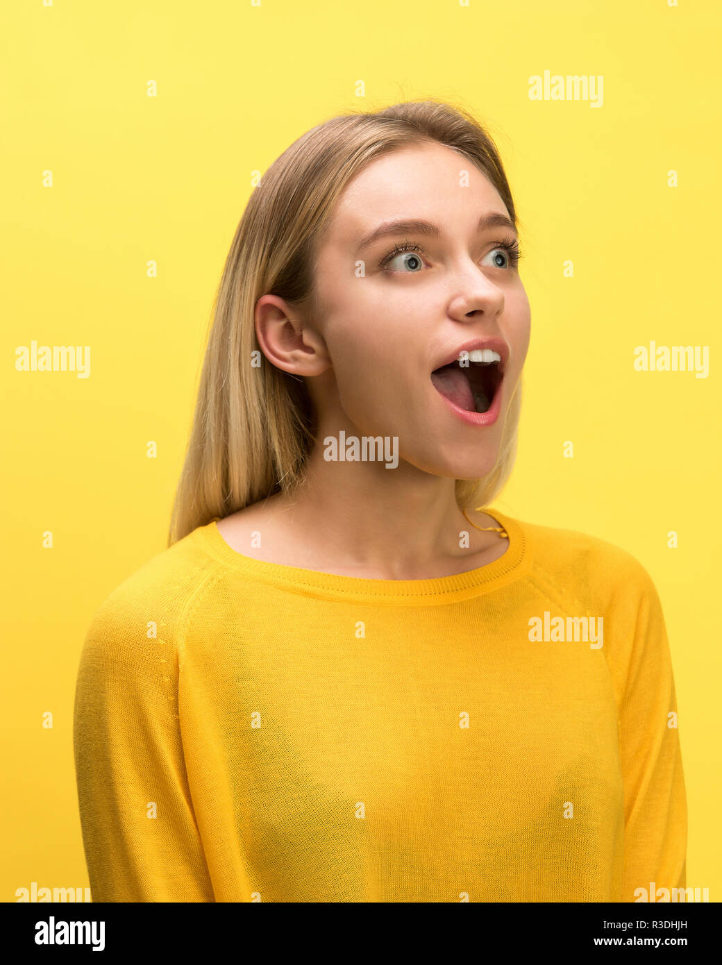 The surprised and astonished young woman screaming with open mouth ...