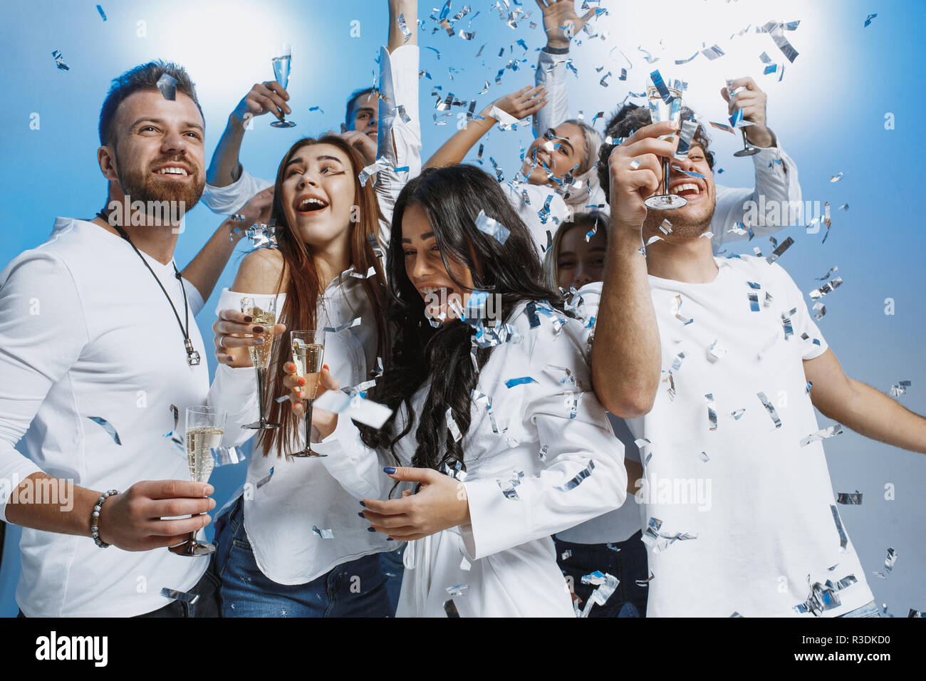 Group of cheerful joyful young people standing and celebrating together ...