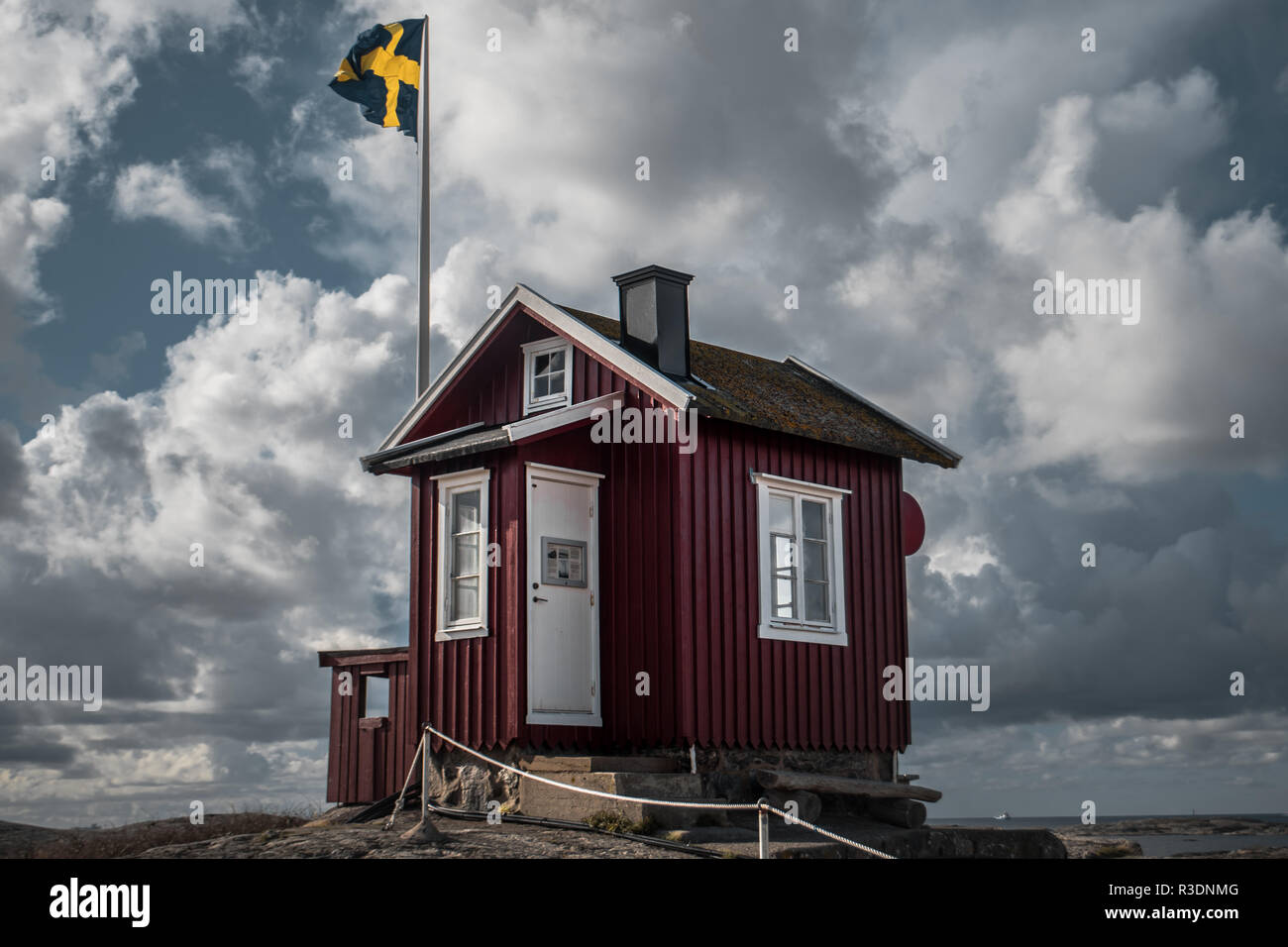 A classic Swedish red hut in front of a Swedish flag in the Gothenburg ...