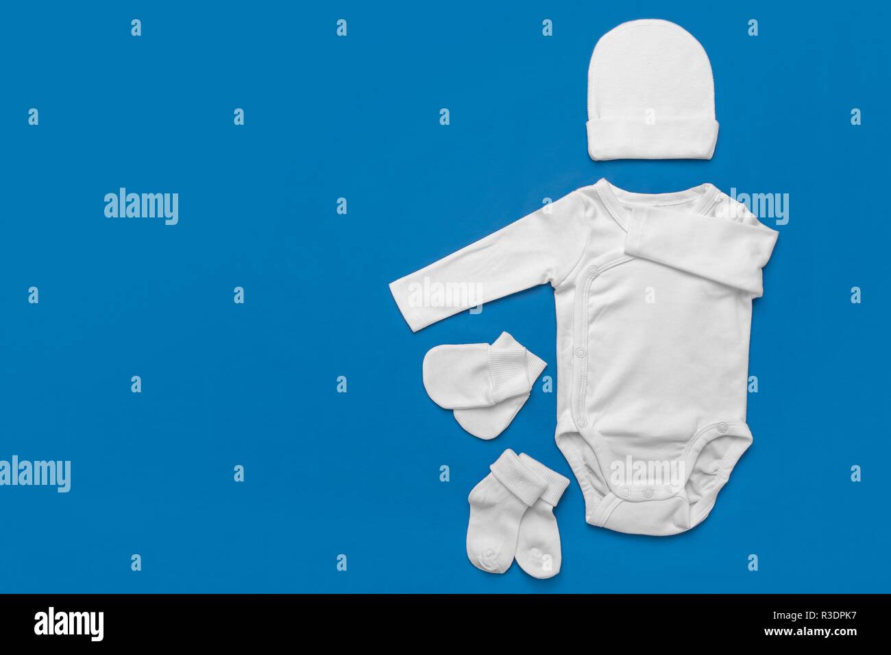 Set of white baby clothes on blue background Stock Photo - Alamy