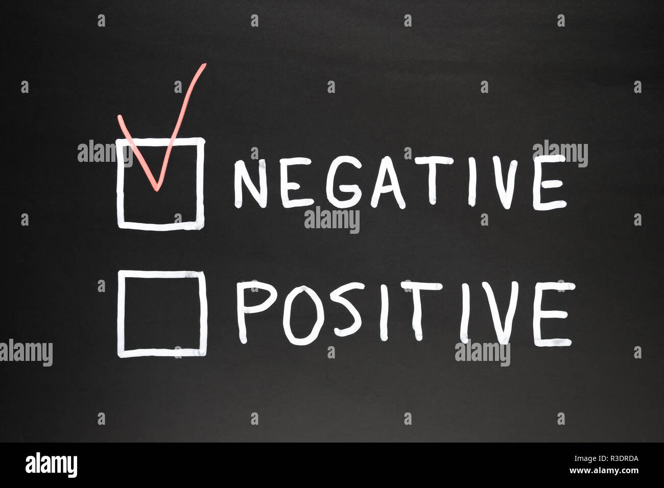 Negative and positive written on a black slate with chalk. In red ...