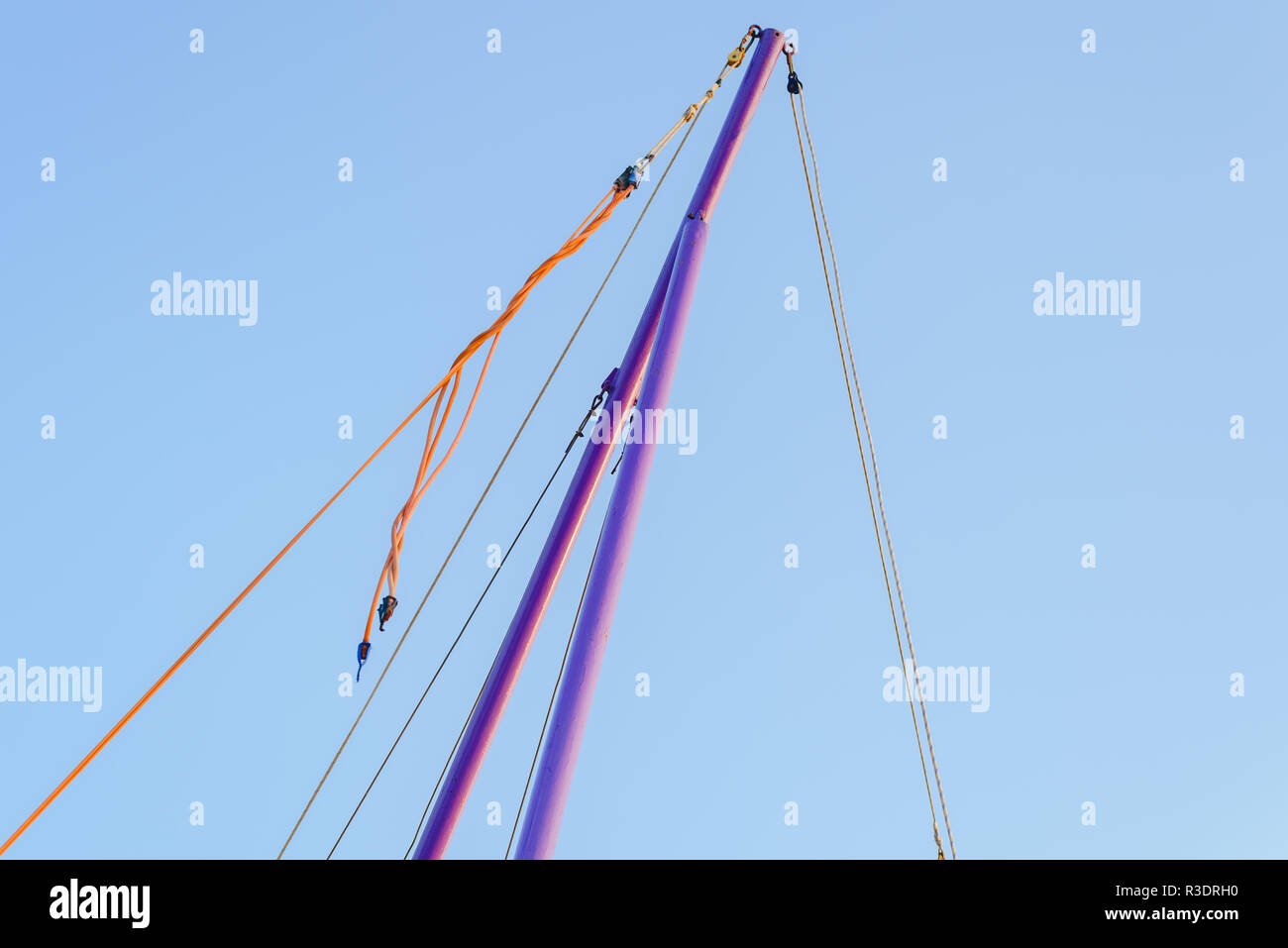 Upper part of boat masts with ropes and blue background Stock Photo - Alamy
