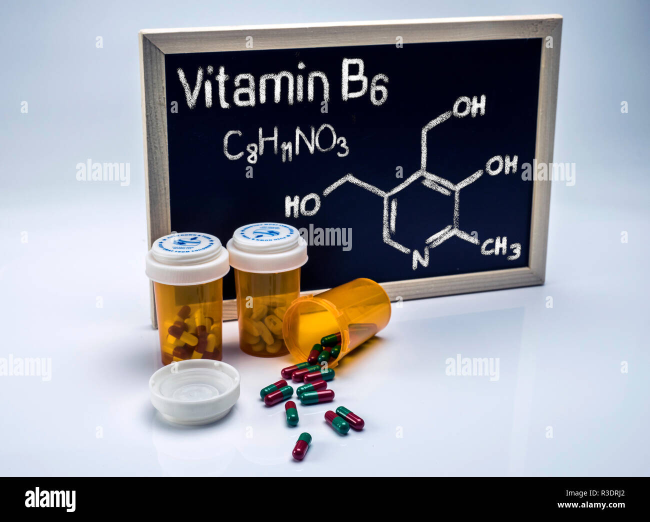 Vitamin B6 written by hand on a whiteboard next to bottles of capsules ...