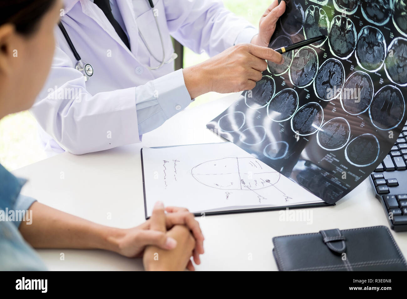 doctor analyzing a scan or x-ray film or explains a CT scan thoughtful ...