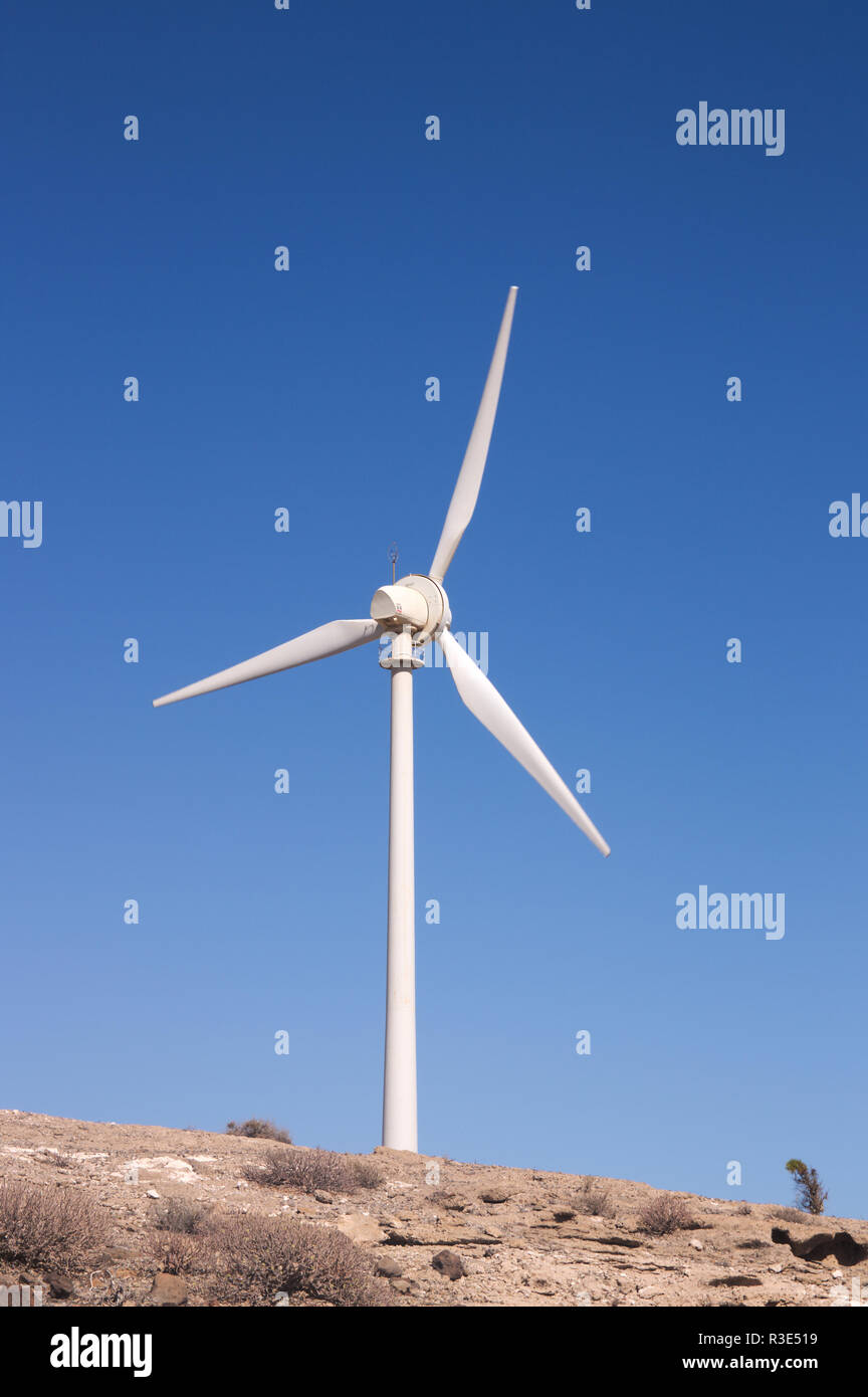 View of an electric wind turbine from afar with a nice blue sky ...