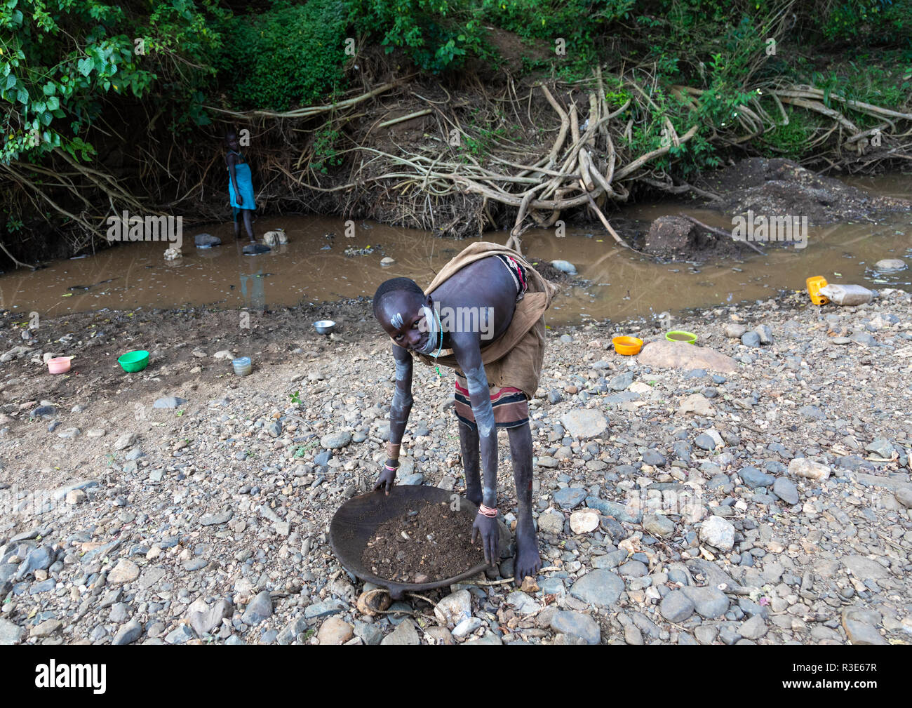 Suri tribe girl doing gold panning in a river, Omo valley, Kibish ...