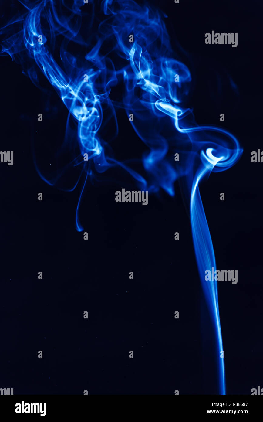 Blue smoke on a black background Stock Photo - Alamy