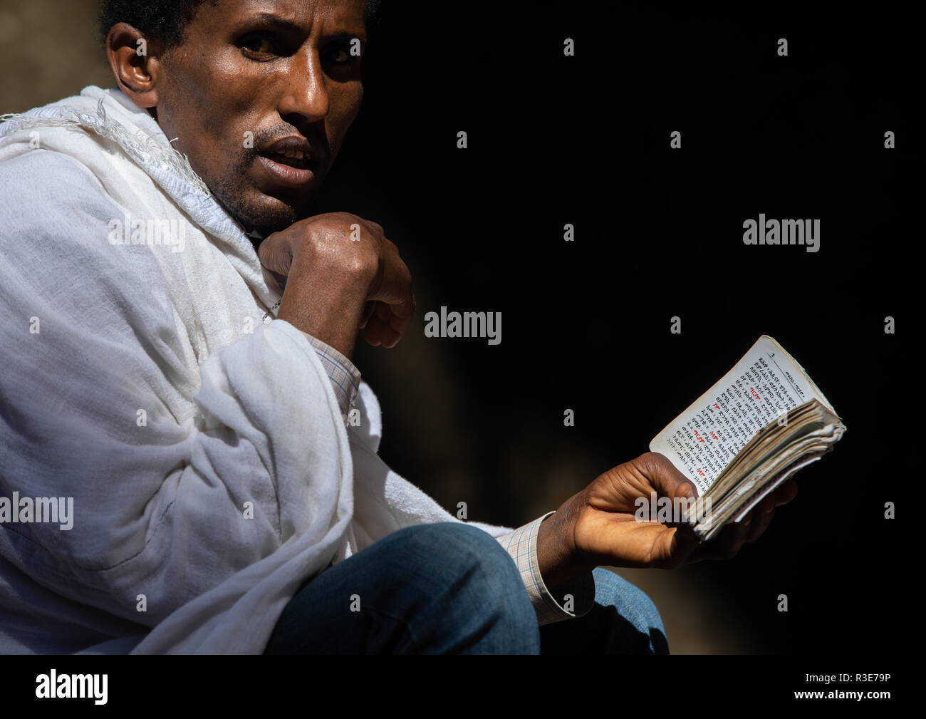 Orthodox man praying with a bible, Amhara Region, Lalibela, Ethiopia ...