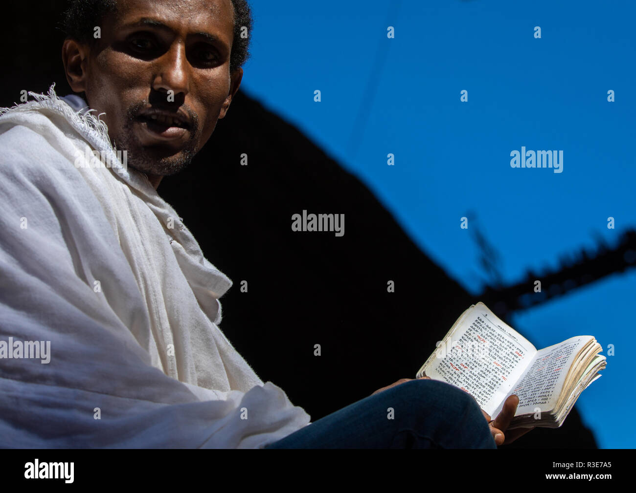 Orthodox man praying with a bible, Amhara Region, Lalibela, Ethiopia ...