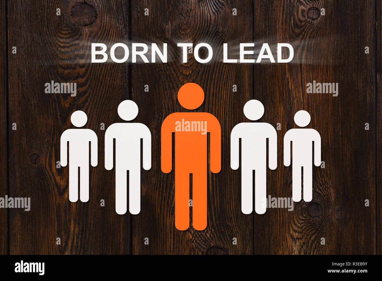 Abstract leadership concept. Paper men figures on wooden background ...
