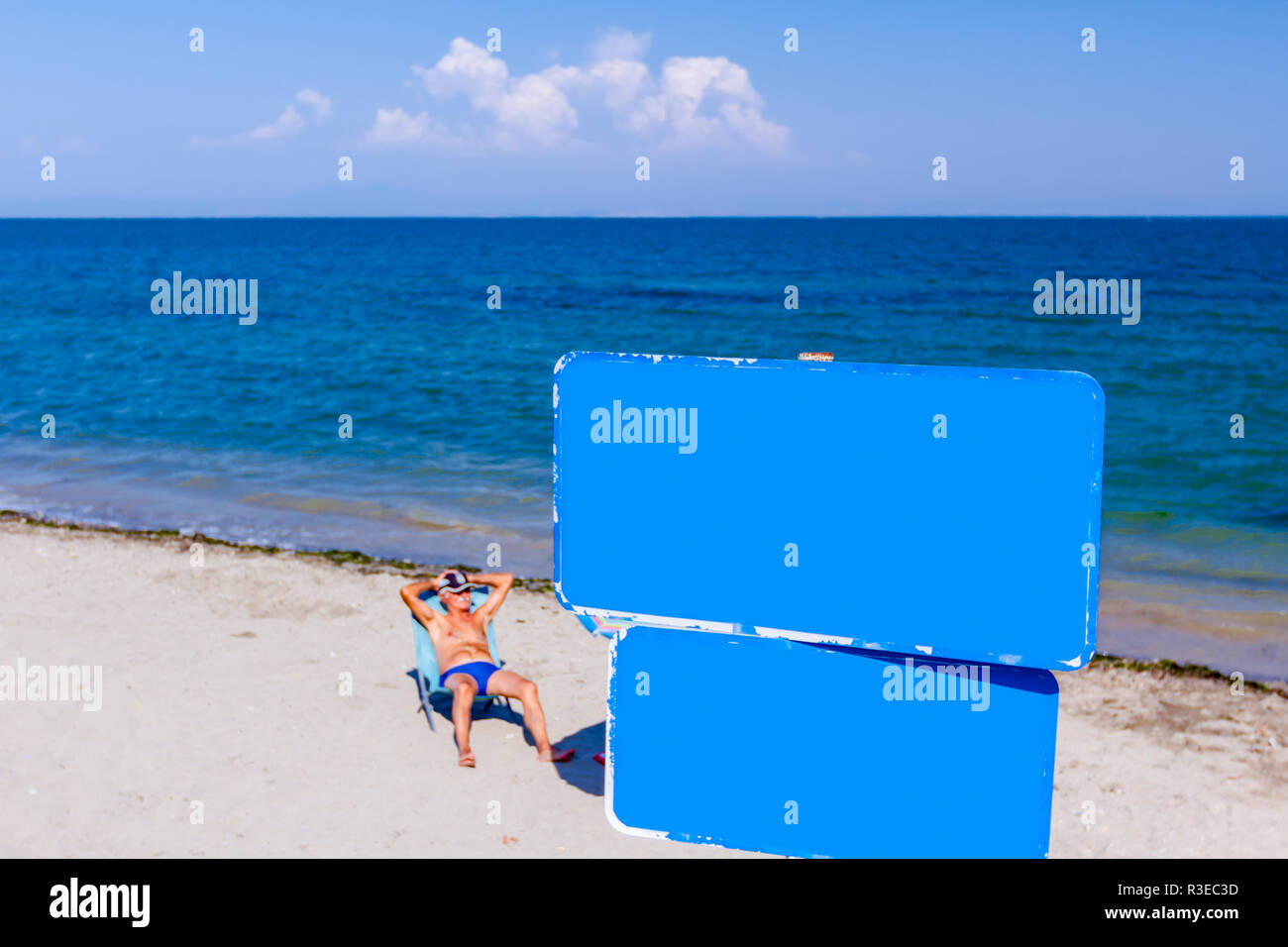 Colored empty wooden board, in background elderly man is relaxing by ...
