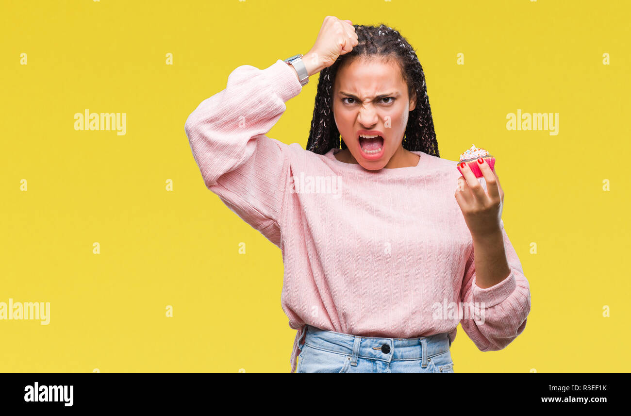 Young african american girl eating cupcake over isolated background ...