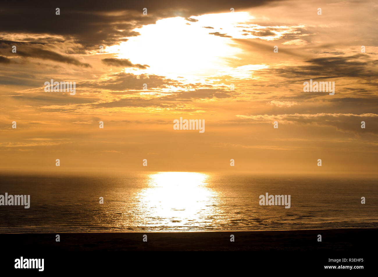 Beautiful sunset over the water by the beach at Waitakere Ranges, West ...