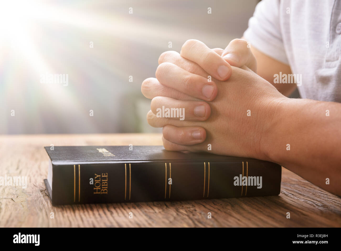 Sunlight Falling On Hand Over Bible While Praying Stock Photo - Alamy