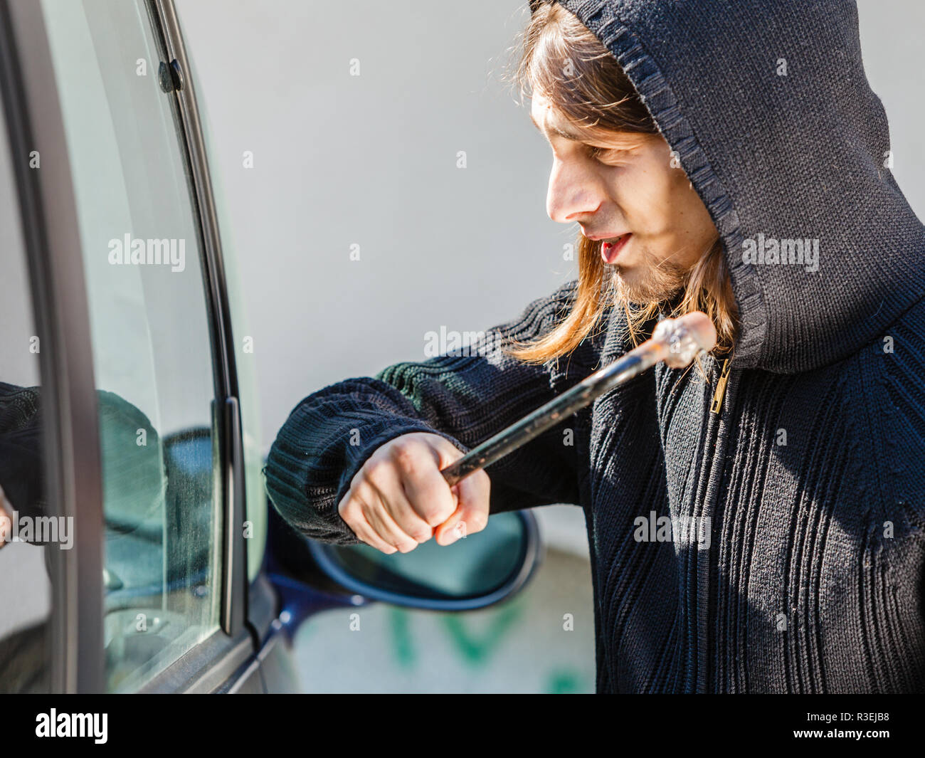 Transportation, crime and ownership concept - Male hooded thief burglar ...