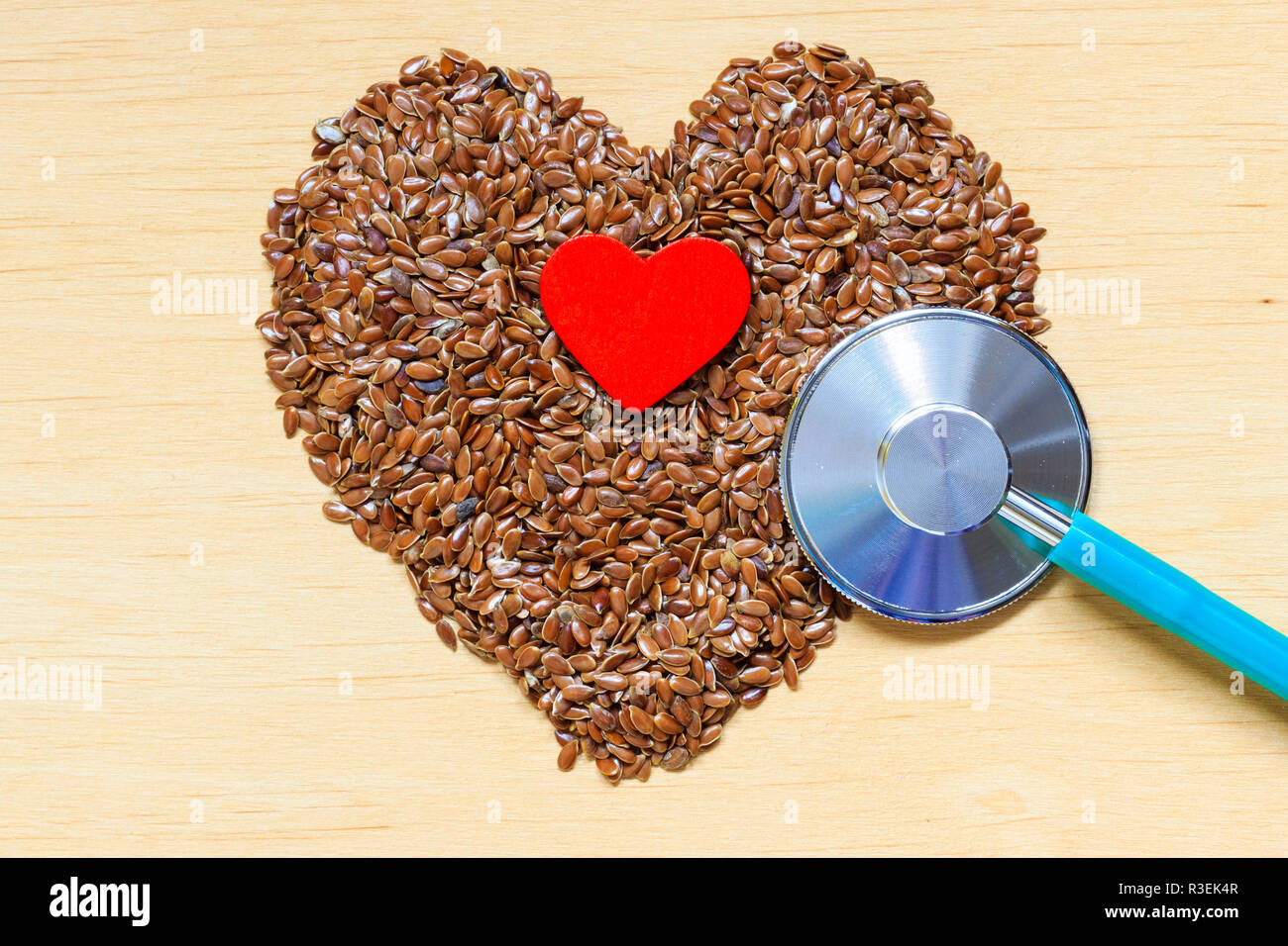 Diet healthcare and checkup concept. Raw flax seeds linseed heart shaped and stethoscope ...