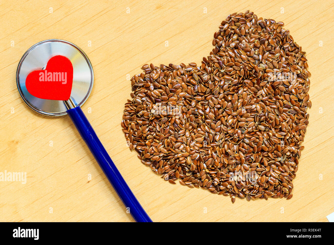Diet healthcare and checkup concept. Raw flax seeds linseed heart shaped and stethoscope ...