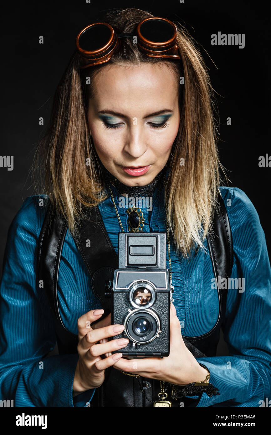 Steampunk. Retro woman with old vintage camera studio shot grunge dark ...