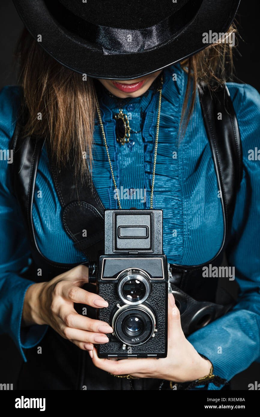 Steampunk. Retro woman with old vintage camera studio shot grunge dark ...