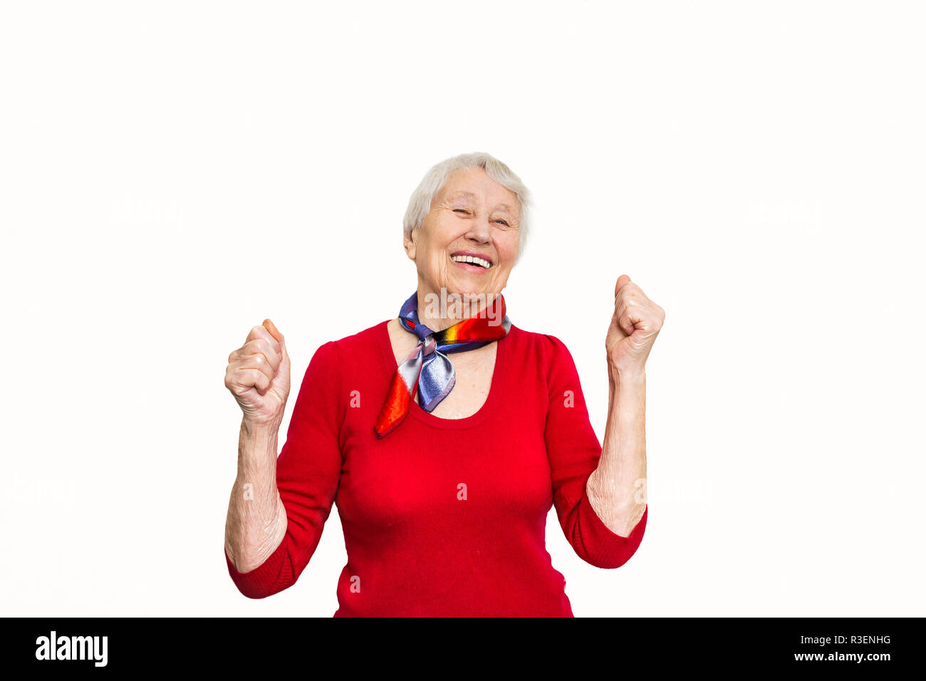 Old smiling woman with surprised expression on her face on red studio ...